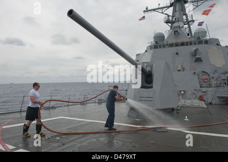 U.S. Navy sailors wash down the flight deck of the aircraft carrier ...