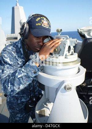 A Sailor stands watch on the forward lookout during a naval deployment ...