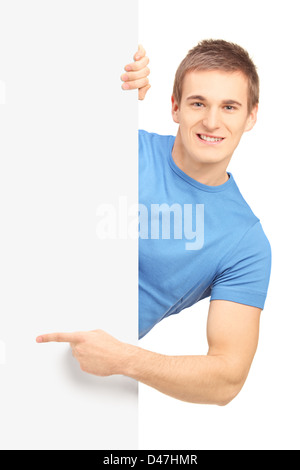 A smiling handsome male posing behind a white panel isolated stock ...