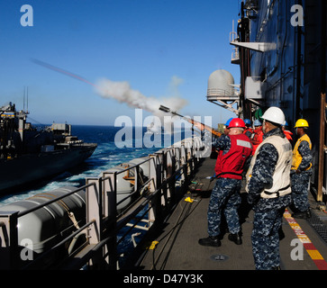 US Navy Sailor fires a shot-line to ship along side during ...