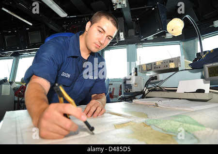 A Sailor plots navigation coordinates on a chart while at sea in the U ...