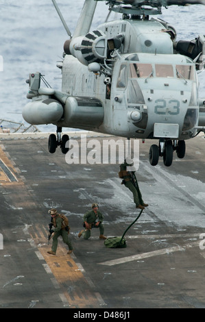 U.S. Marines fast-rope from a U.S. Navy MH-60S Sea Hawk helicopter ...