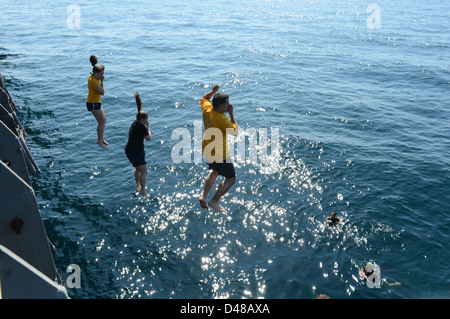 Sailors jump to the sea during a swim call aboard USS Carl Vinson Stock ...