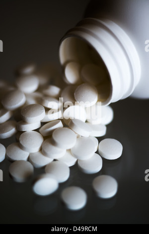 Aspirin tablets falling out of a jar Stock Photo - Alamy