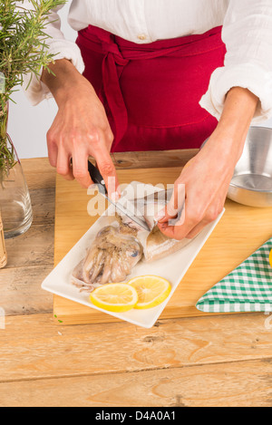 Cleaning a cuttlefish to be cooked Stock Photo - Alamy