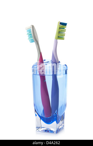 Colorful Toothbrushes in glass on blue wood background. Dental and oral ...