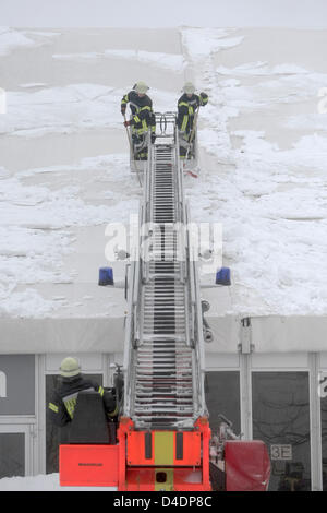 Firemen free snow from the roof of a large tent in Mainz, Germany, 12 ...