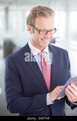 Happy and confident businessman using tablet Stock Photo - Alamy