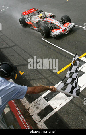 Mercedes driver Lewis Hamilton crosses the finish line to win the ...