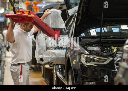 An employee of the Audi Factory lifts seat into an Audi A3 on the ...