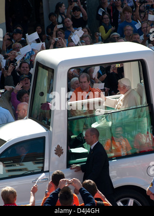 Pope Benedictus XVI in the Popemobile amidst a crowd of flag waving ...