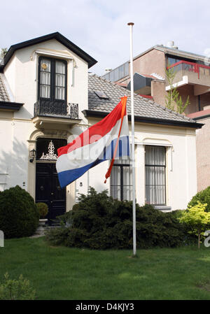The Dutch flag flies at half-mast from a traditional brick building ...