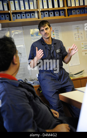 A Coast Guard vessel conducts an inspection of piers at the Port of ...