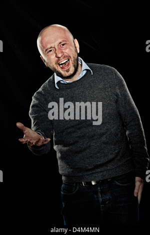 Man smiling at camera, arm outstretched, showing palm Stock Photo - Alamy