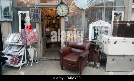 Antique shop exterior display with chairs, pile of old suitcases and ...