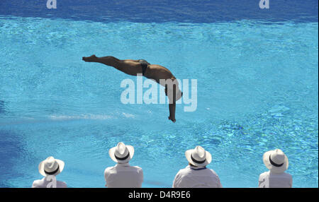 Judges watch as Chinese He Chong performs during 3m diving competition ...