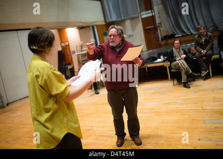 A director with his Actors in rehearsal, holding their scripts, reading ...