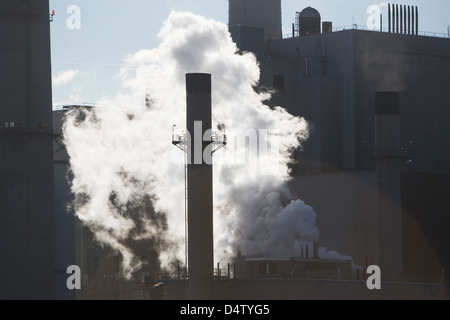 a plume of smoke or steam from an industrial smokestack on a clear blue ...