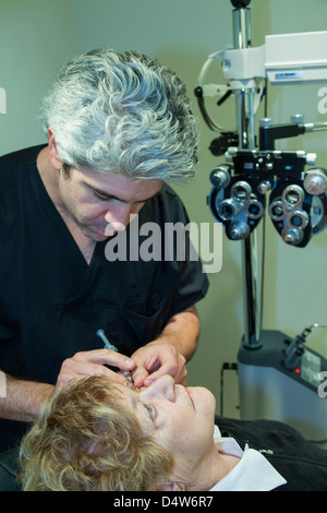 Doctor giving injection to senior man at hospital. Nurse holding ...