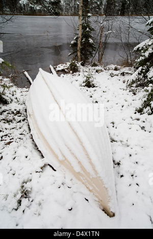 Lone moored boat covered in snow in small lake inlet Stock Photo - Alamy