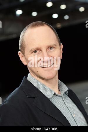 British writer and journalist Chris Cleave poses with his book 'Gold ...