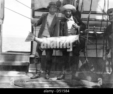 Two crew with large fish onboard HMS 'Penguin' Stock Photo - Alamy