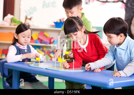 Cute kindergarten children placing flags on world map Stock Photo - Alamy