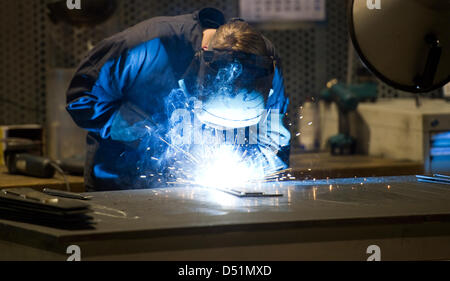 A welder welds a piece of metal in the factory, industrial work Stock ...