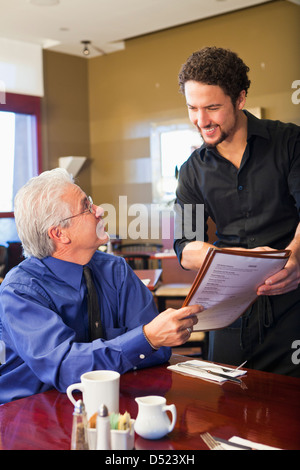 Two men ordering food and talking with waitress in restaurant Stock ...