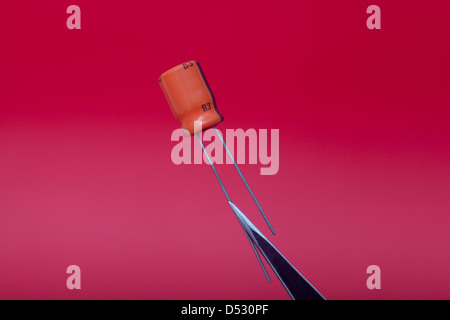 Detail of capacitor in red background Stock Photo - Alamy