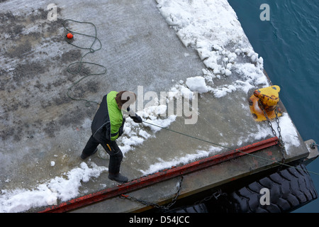 dock worker pulling on ships ropes for hurtigruten passenger ship on ...
