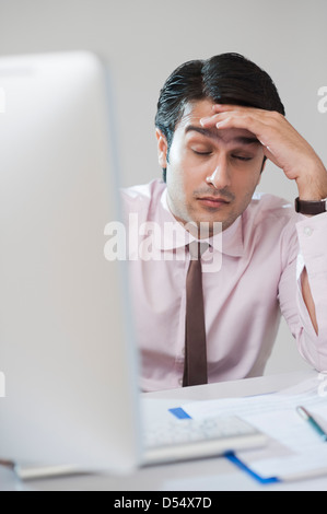 Young indian businessman looking tired Stock Photo - Alamy