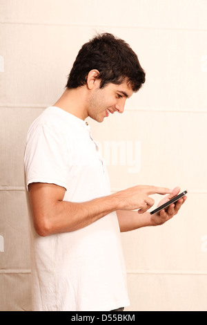 Young hispanic man using touchpad sitting on bed at bedroom Stock Photo ...