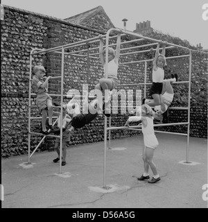 1950s, historical, nursery school boys and girls play on a metal ...