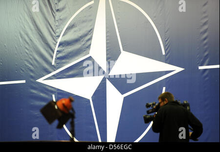 A NATO insignia is surrounded by lights and cameras at the press centre ...