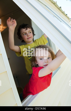 Boy of elementary age opens the window for ginger cat Stock Photo - Alamy