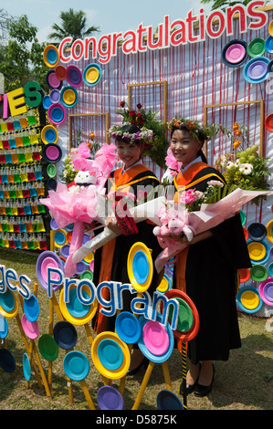 Southeast-Asian university female graduate in graduation gown with ...