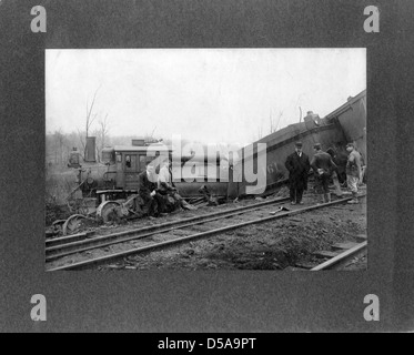 A photograph showing the aftermath of a railroad wreck. The image ...