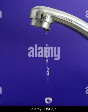 Water droplets falling from a kitchen tap into a digitally created pool ...