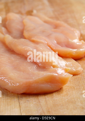 Composition of raw fresh chicken fillet placed on black surface near ...