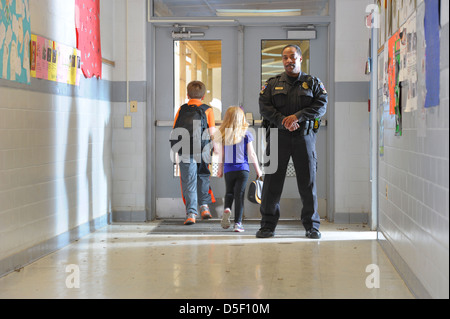 USA Safety in public schools Police officer with boy and girl in school ...
