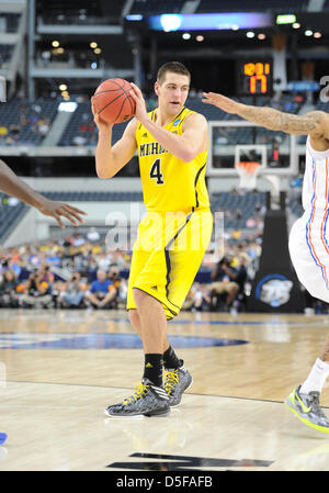 Michigan Wolverines forward Mitch McGary (4) holds up a piece of the ...