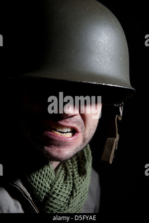 Portrait of a WW2 U.S. soldier shouting, with deep shadows against a ...