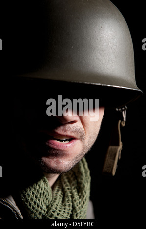 Portrait of a WW2 U.S. soldier shouting, with deep shadows against a ...