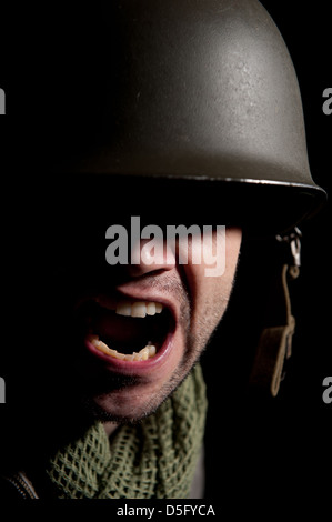 Portrait of a WW2 U.S. soldier shouting, with deep shadows against a ...