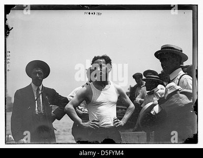 The image shows Harry Houdini performing an escape trick in front of ...