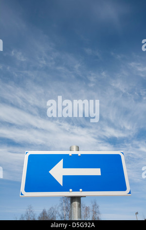 traffic sign arrow pointing left against sky Stock Photo - Alamy