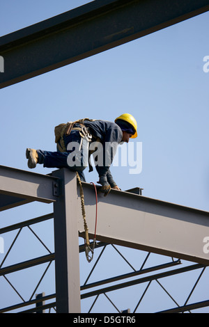 Ironworker connecting steel beams during construction of a building ...