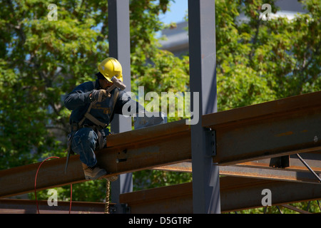 Ironworker connecting steel beams during construction of a building ...