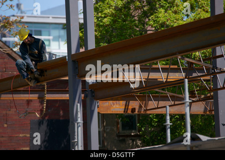 Ironworker connecting steel beams during construction of a building ...